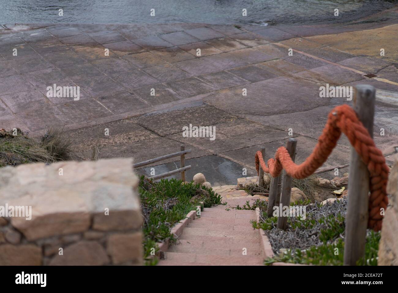 From above stairs with rope handrail leading to concrete embankment ...