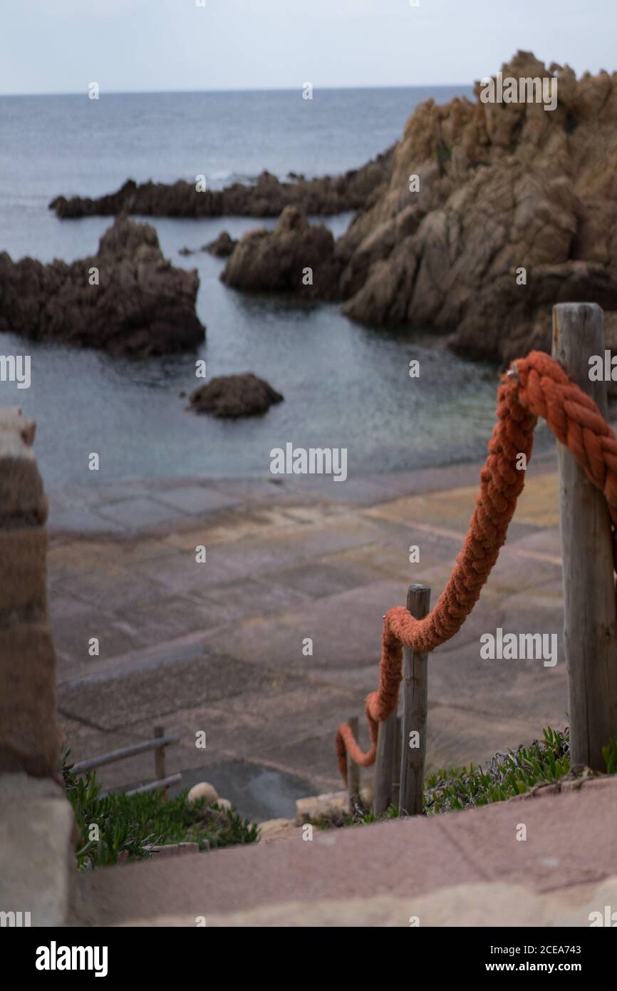 From above stairs with rope handrail leading to concrete embankment ...