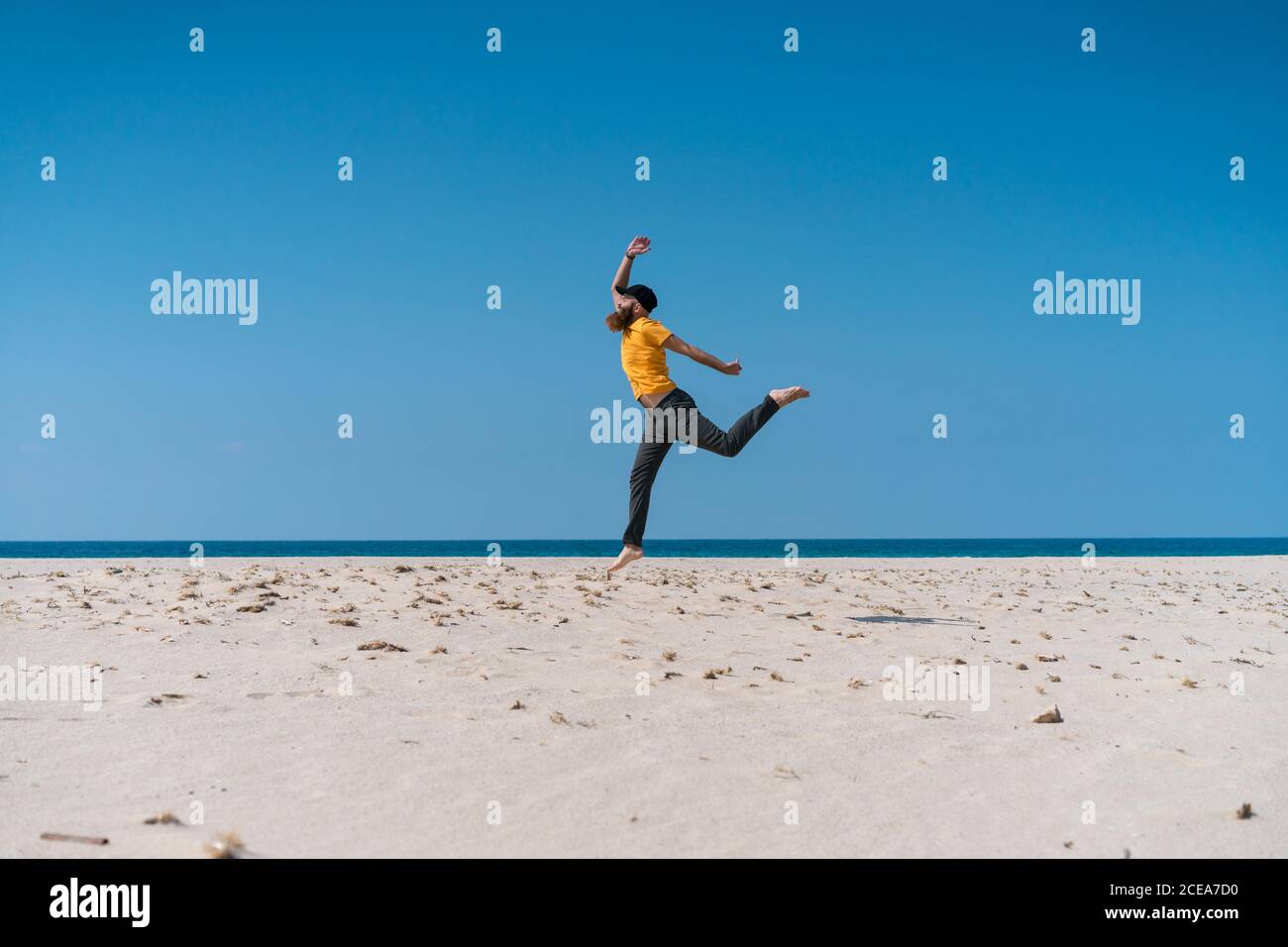 Side view of bearded man falling to sand on beach at the ocean Stock ...
