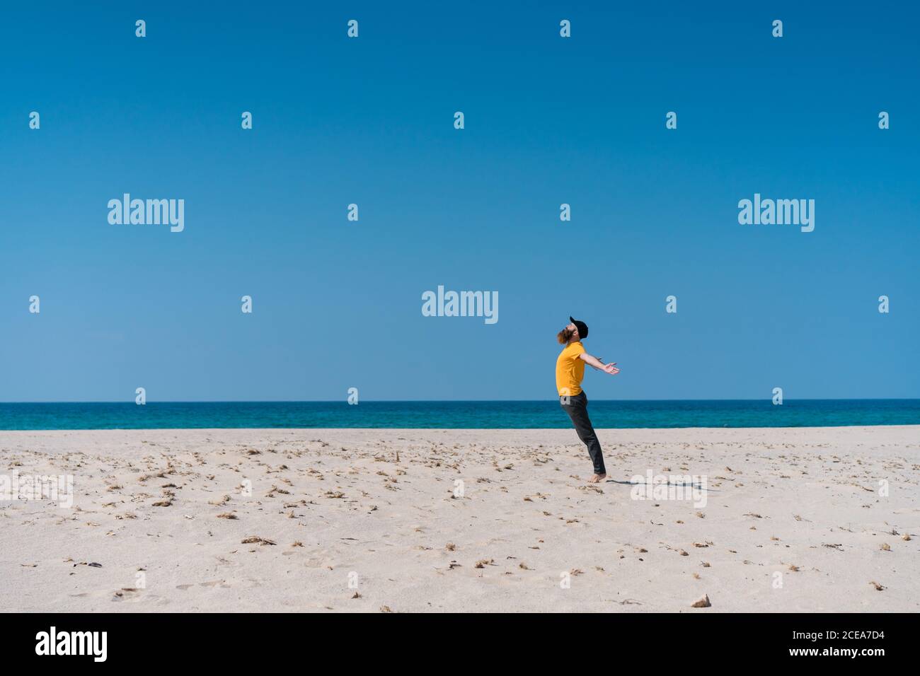 Side view of bearded man falling to sand on beach at the ocean Stock ...