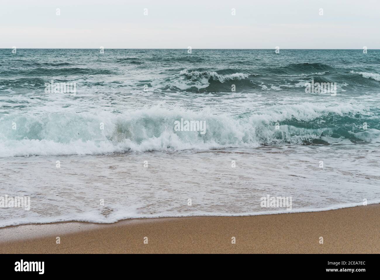 Beautiful wavy seascape view and sandy beach in cloudy day Stock Photo ...