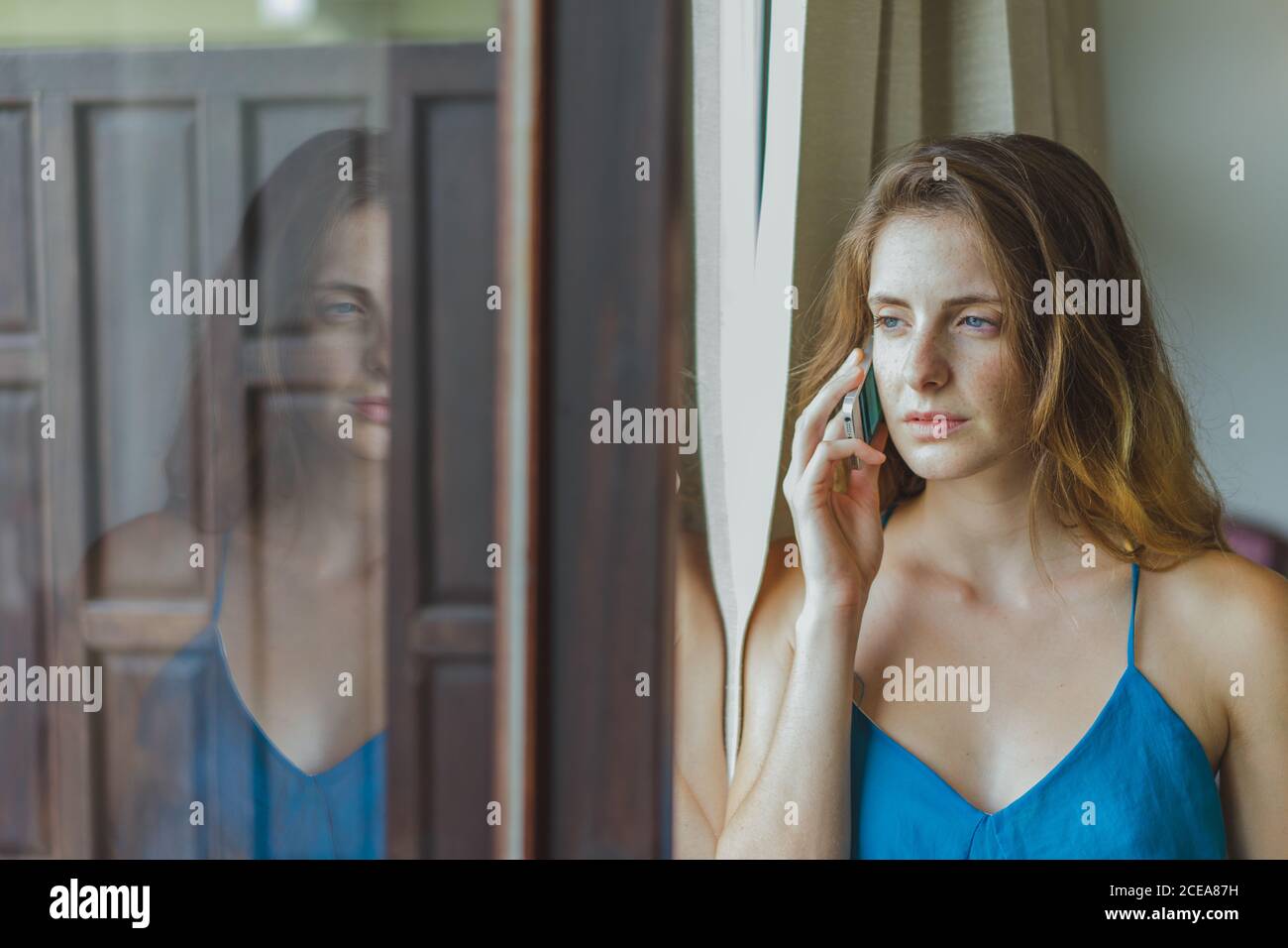 Woman talking at window Stock Photo - Alamy
