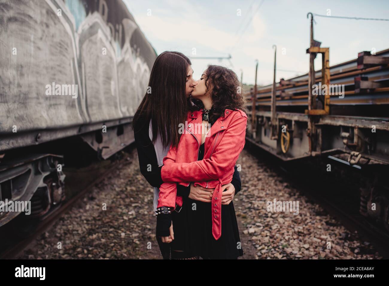 Long haired man hugging and kissing Woman near train Stock Photo - Alamy