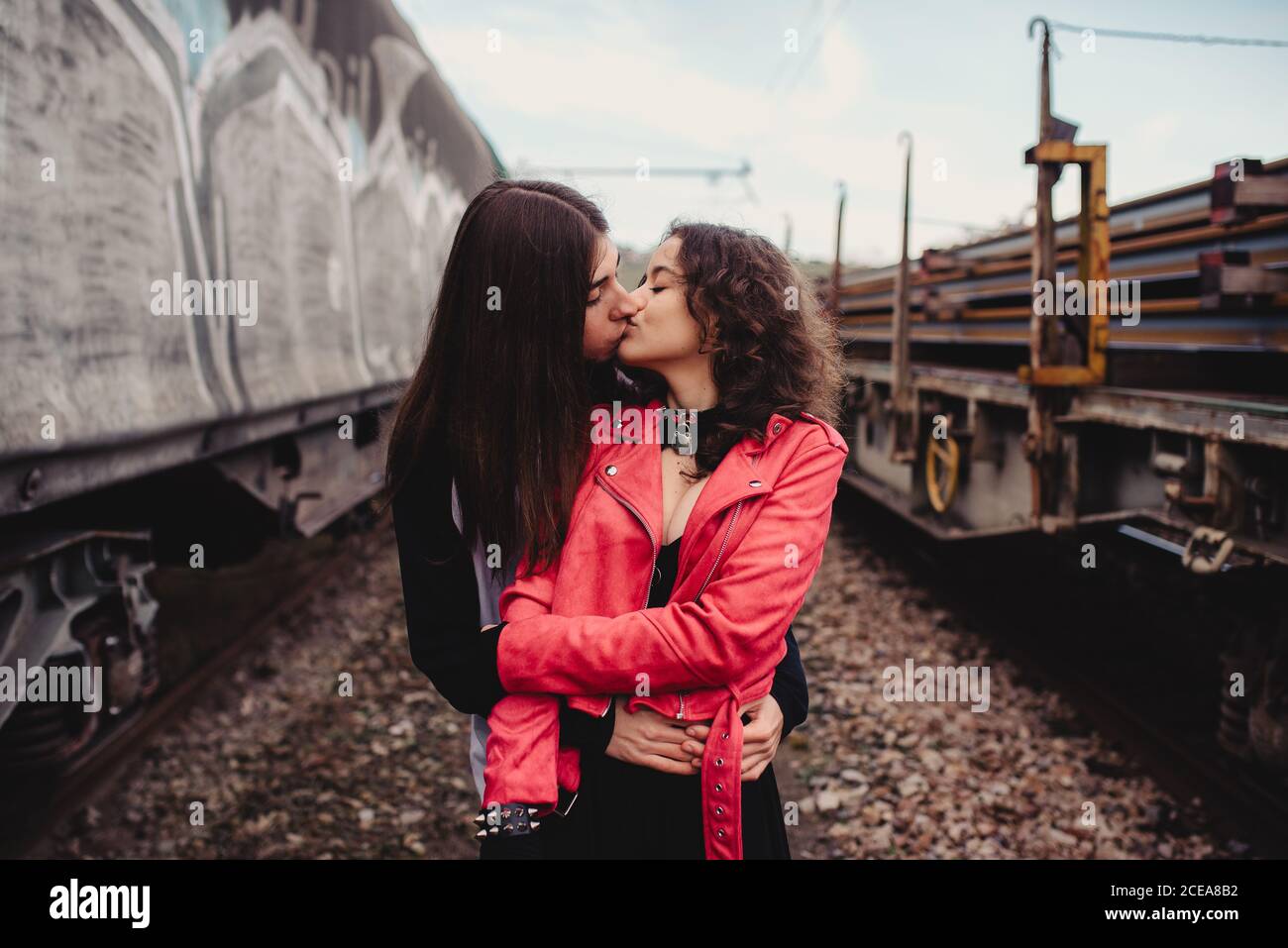 Long haired man hugging and kissing Woman near train Stock Photo - Alamy
