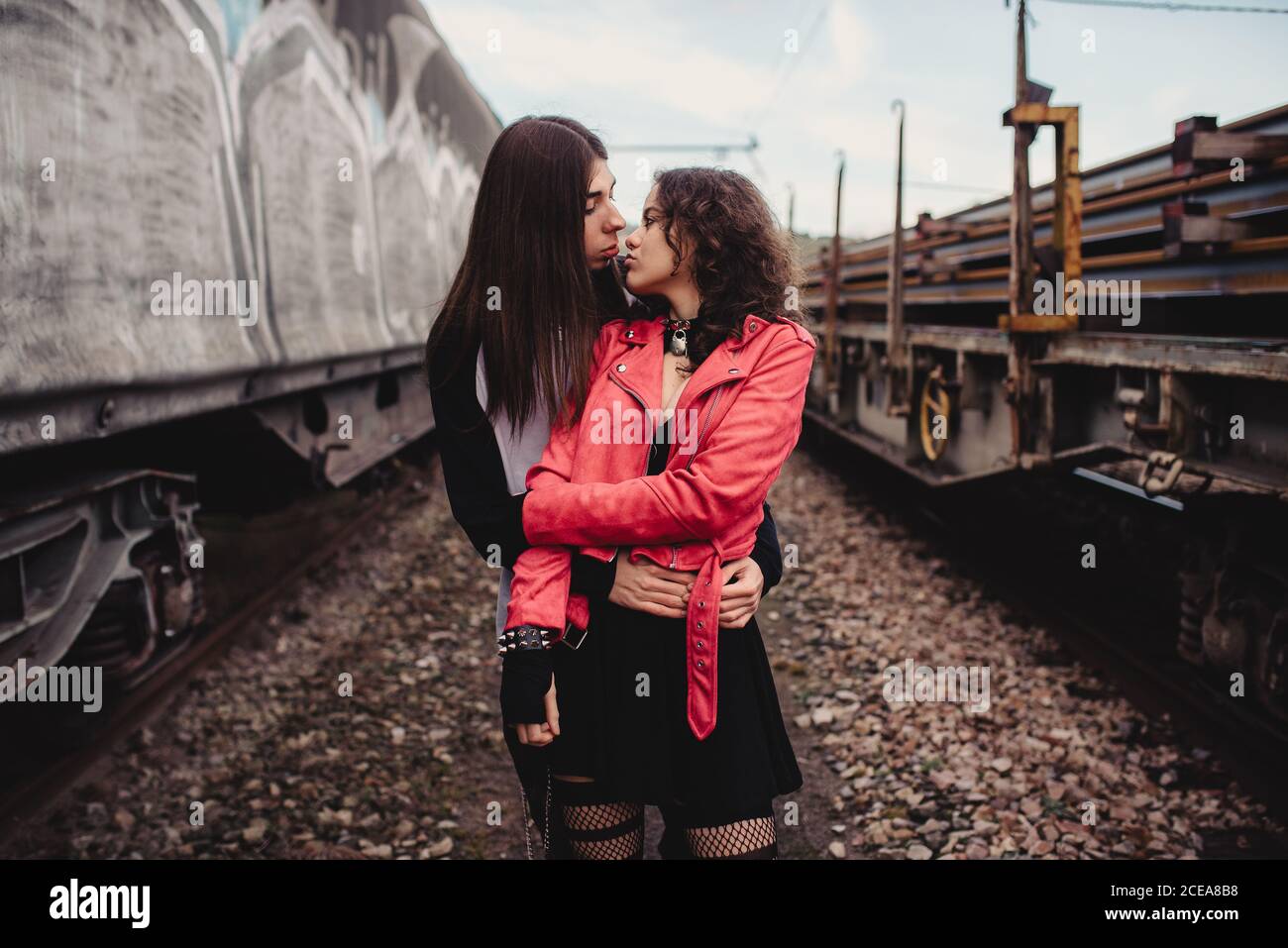 Long haired man hugging and kissing Woman near train Stock Photo - Alamy