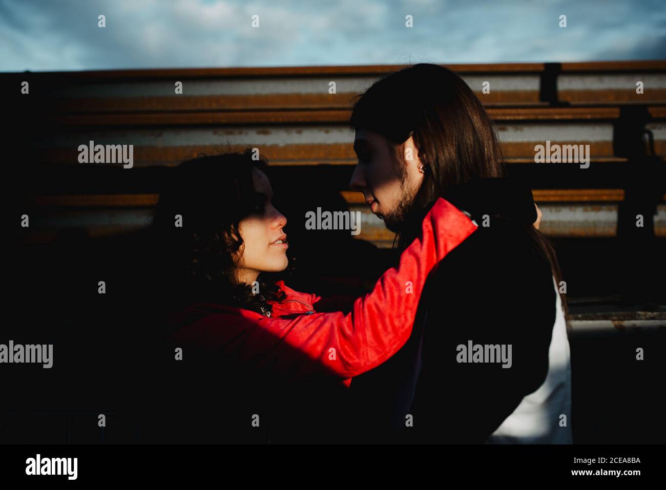 Long haired man hugging and kissing Woman near train Stock Photo - Alamy