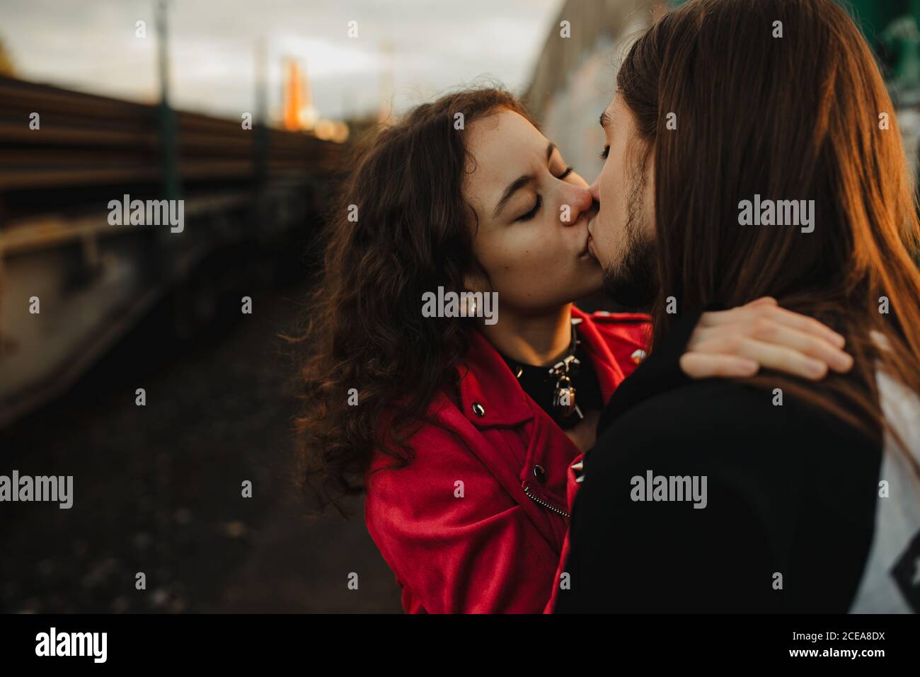 Long haired man hugging and kissing Woman near train Stock Photo - Alamy