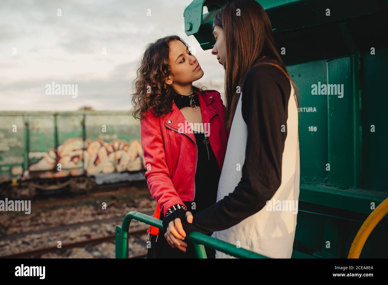 Long haired man hugging and kissing Woman near train Stock Photo - Alamy