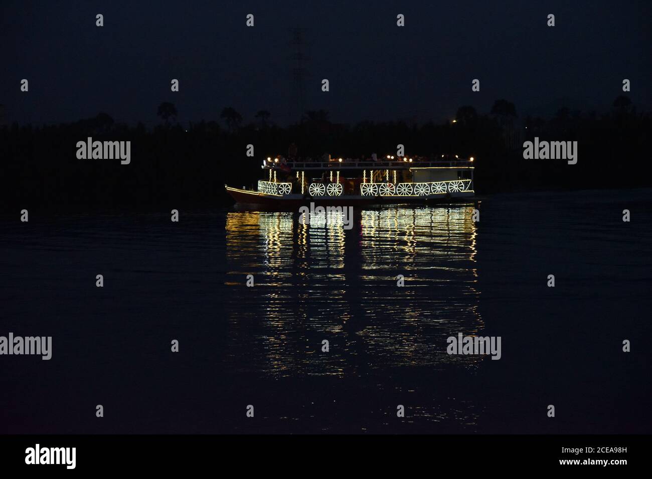 Illuminated boat and its reflection on the water, firefly watching tour ...