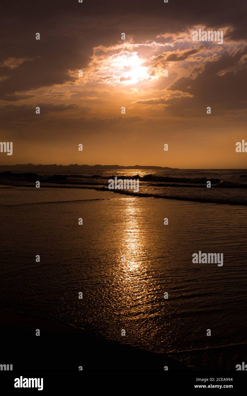 Majestic view of cloudy evening sky over wonderful waving sea and wet ...