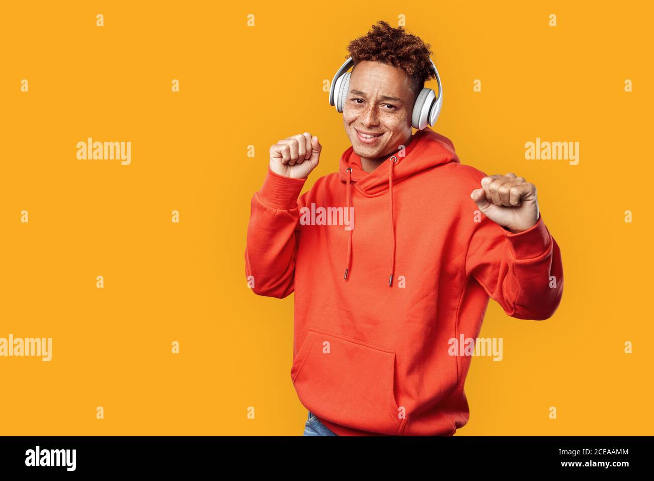 Freestyle. Mulatto freckled guy in hoodie and headphones standing ...