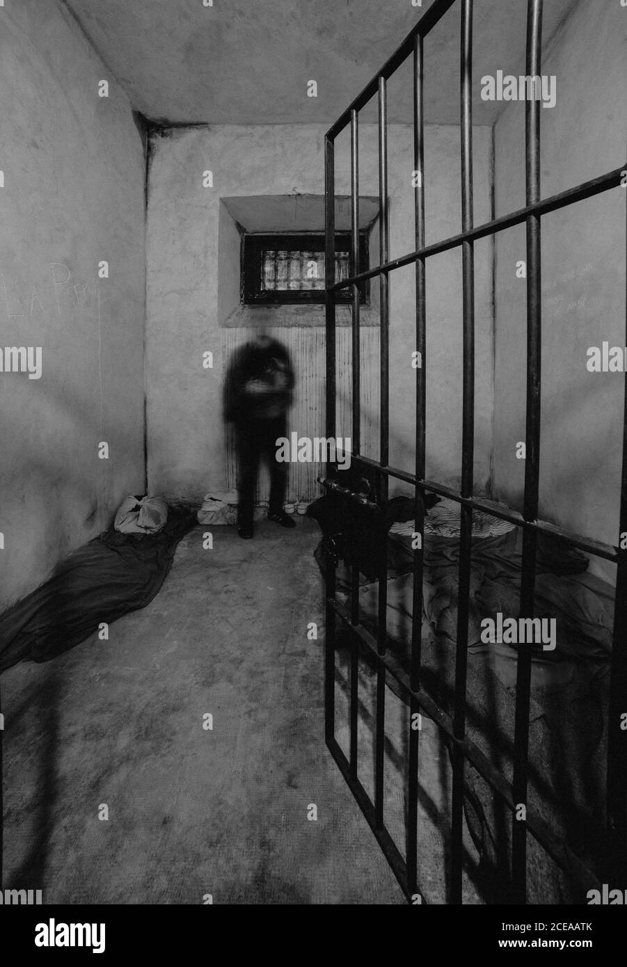 unrecognizable blurred man standing near grungy concrete wall inside ...