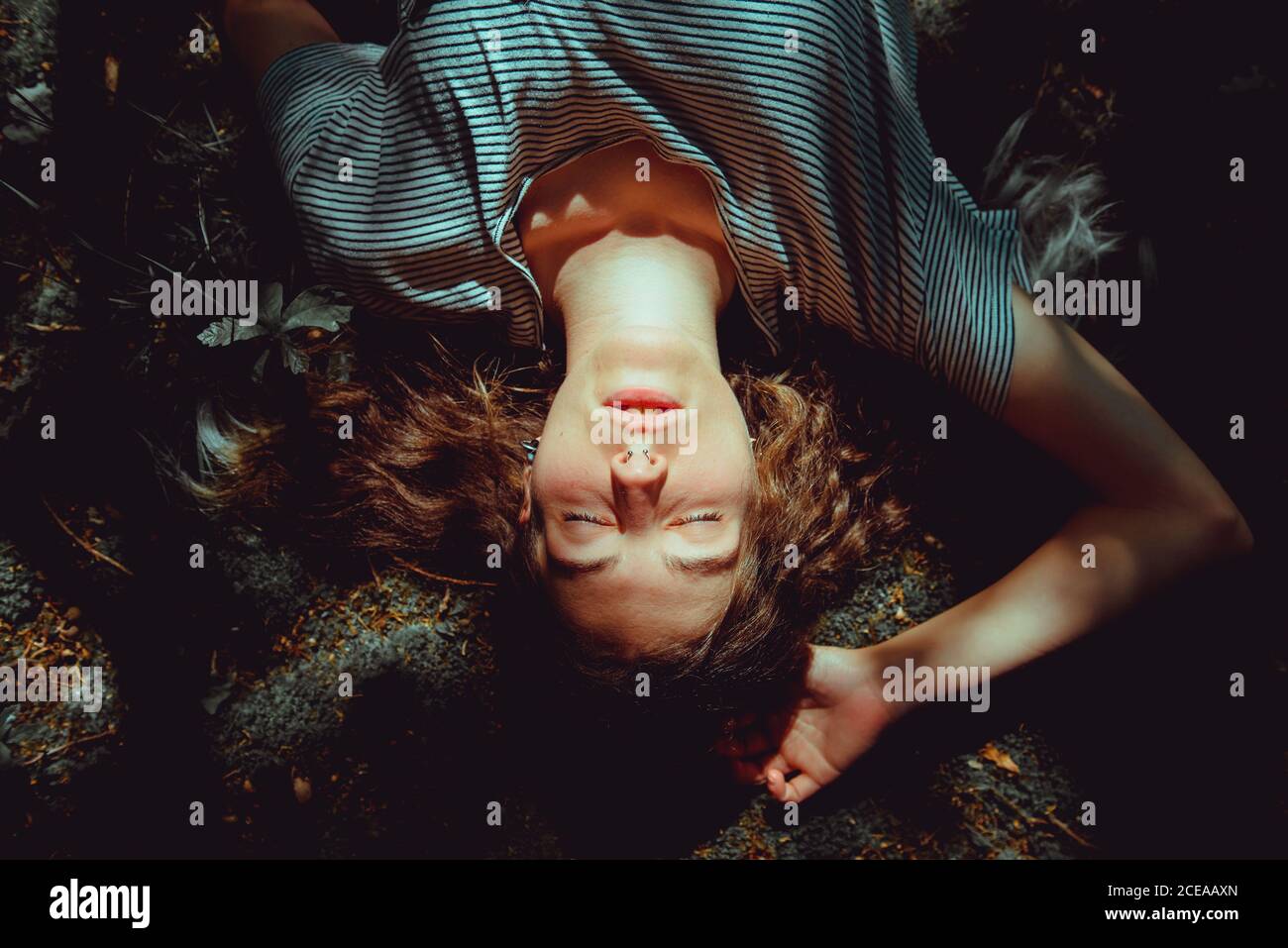 Woman lying on ground Stock Photo - Alamy