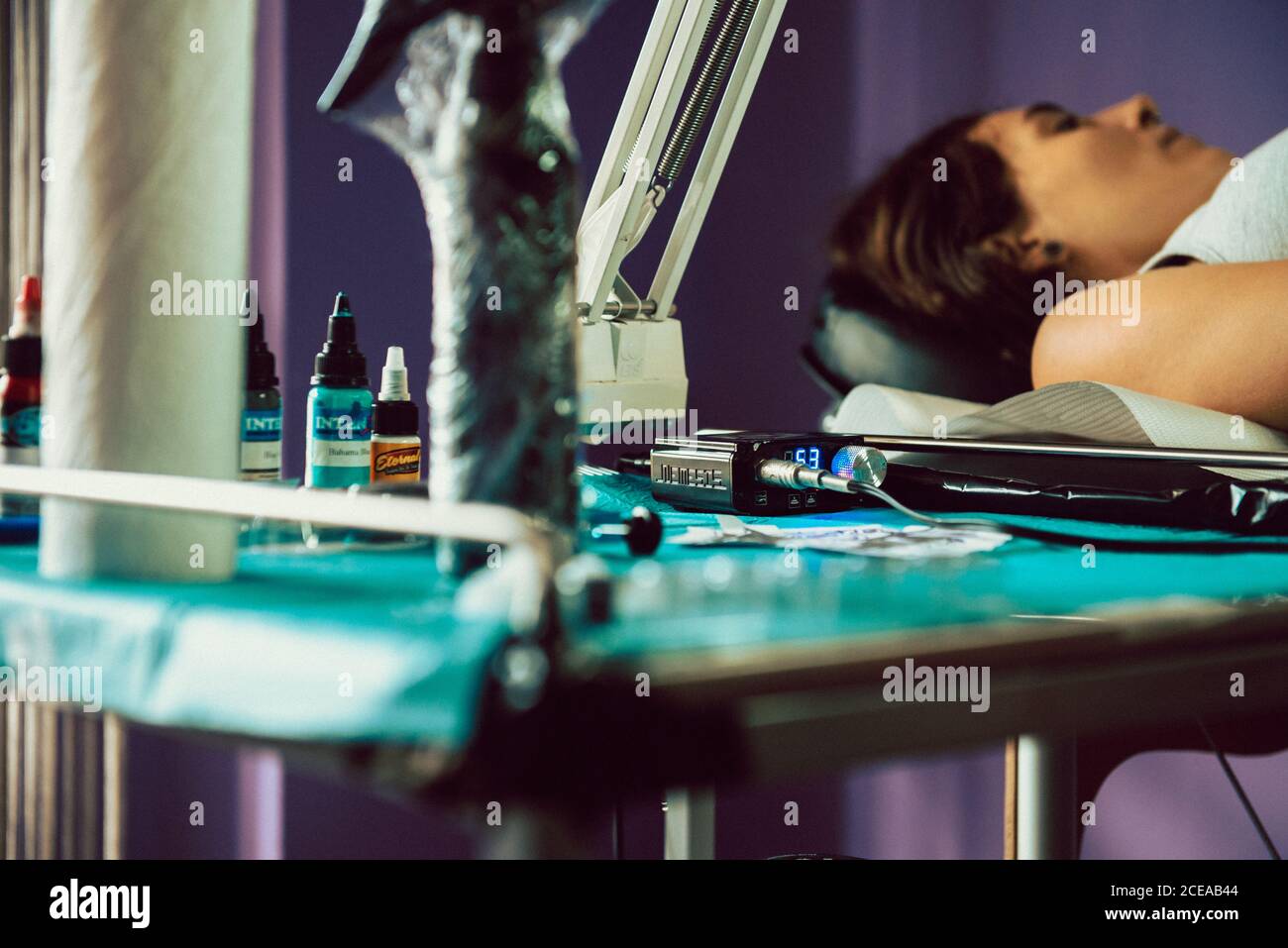 Modern tattoo tool and assorted ink standing on metal table in ...