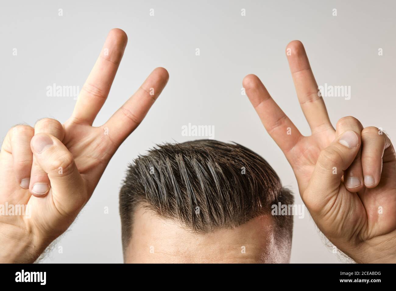 Man with modern and stylish haircut after barbershop shows peace sign ...