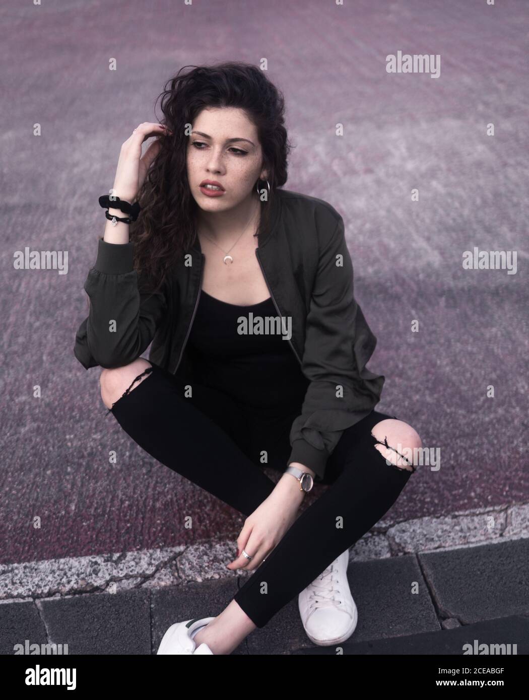 Young Woman sitting on ground Stock Photo - Alamy