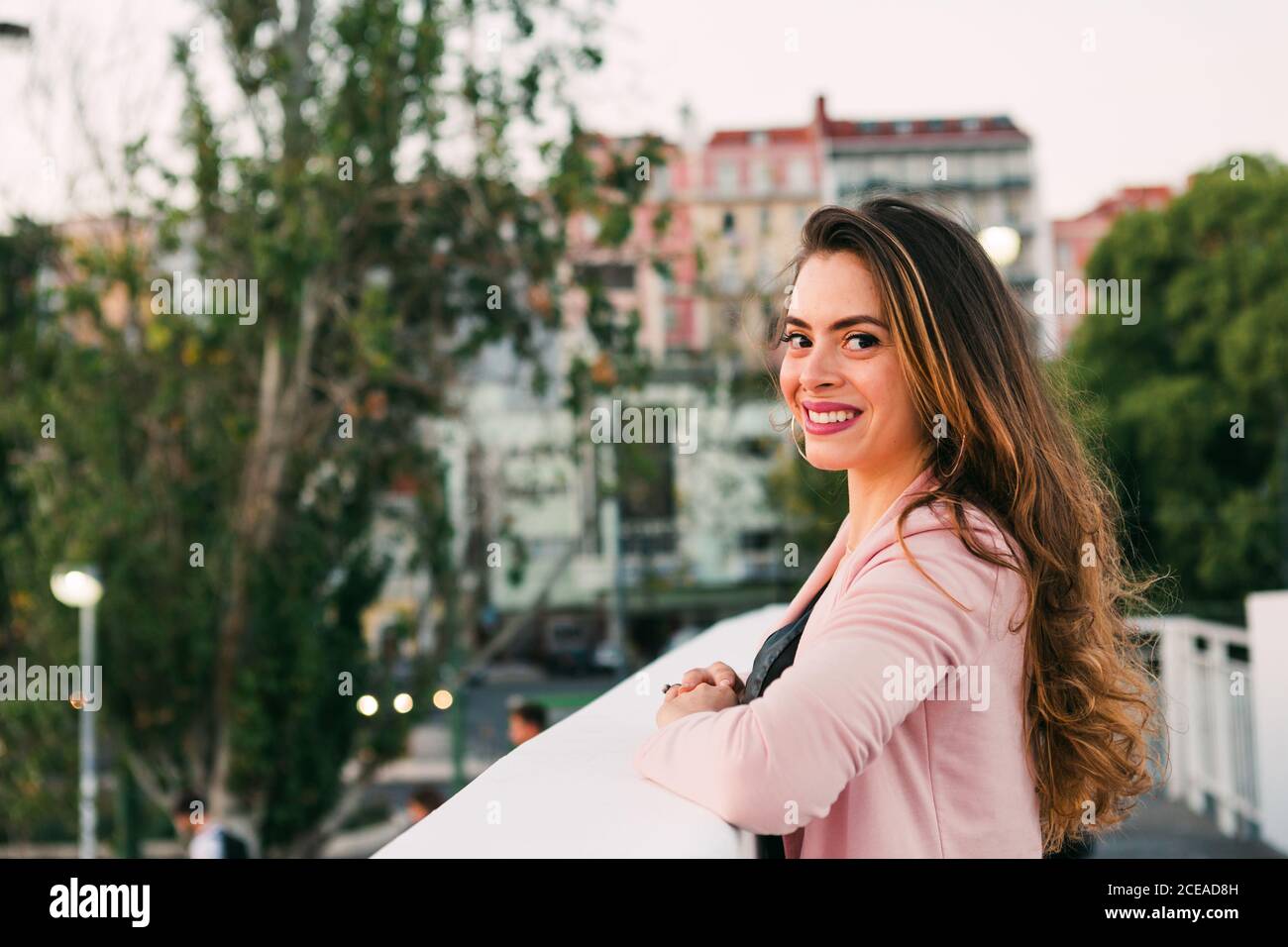 Side view attractive charming lady looking at the camera on footbridge ...
