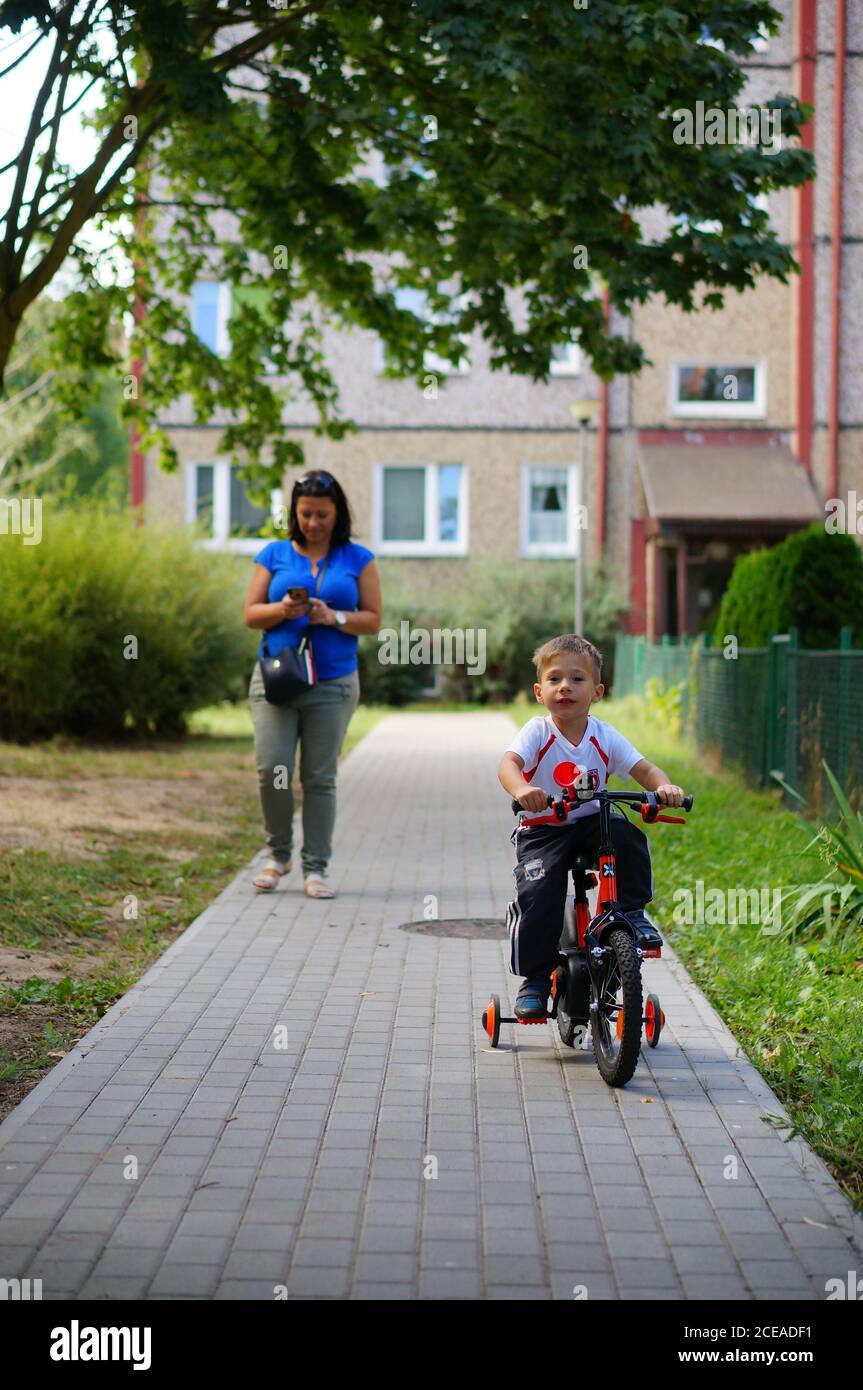 Woman and child on a small bicycle Stock Photo - Alamy