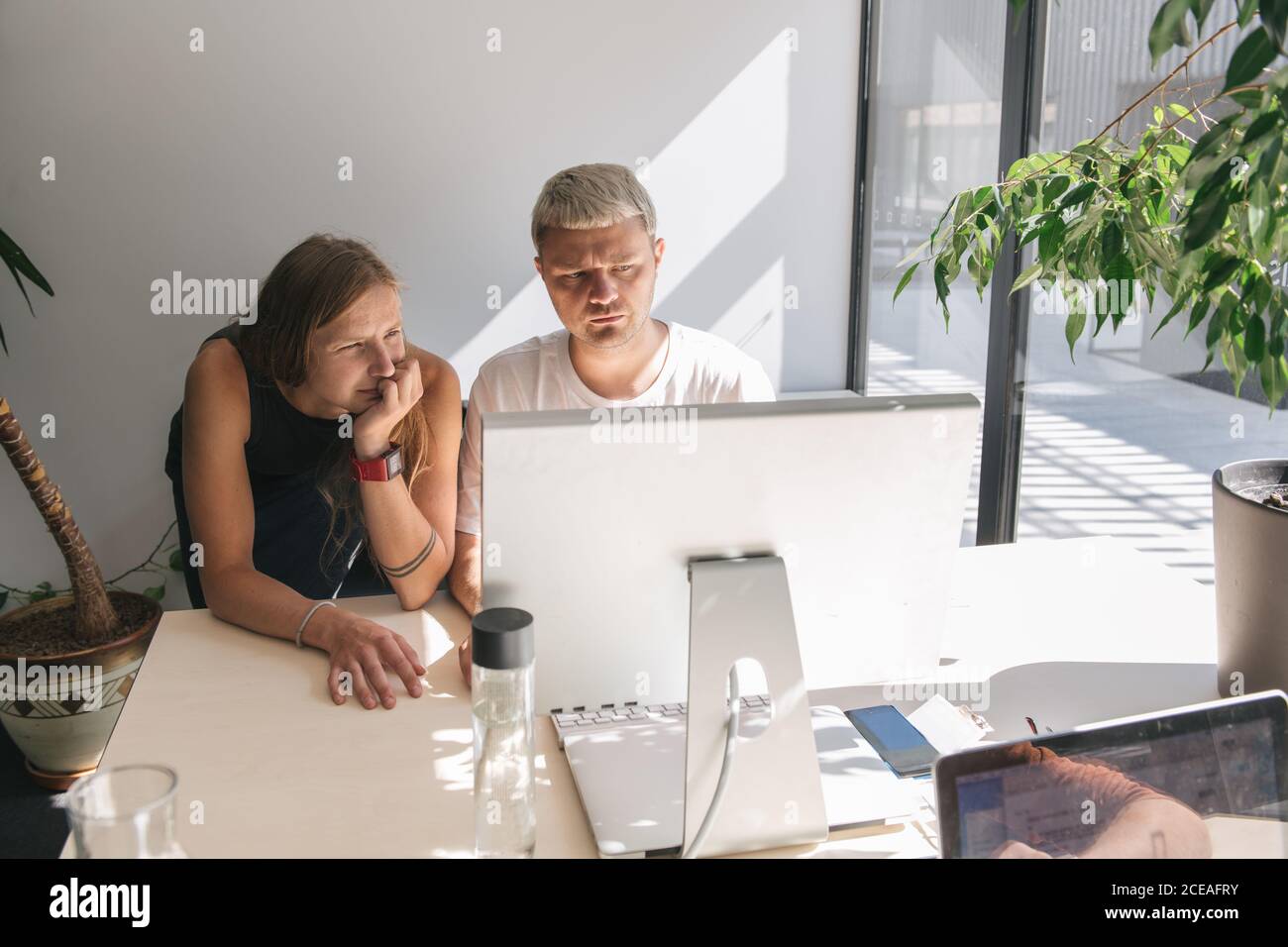 Men sitting at tables in front of each other inside of open space ...