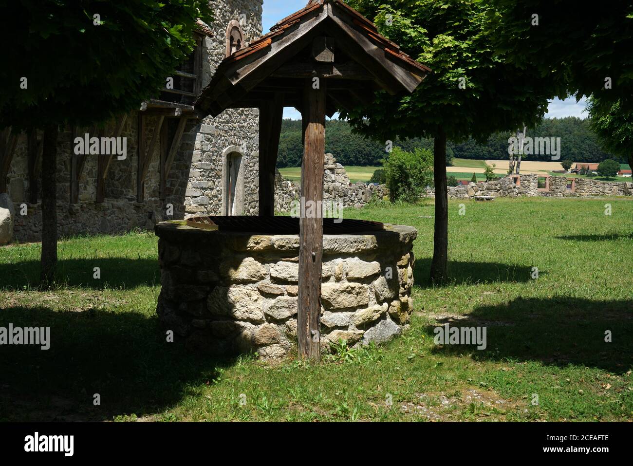 Stone well in the cozy backyard of the building Stock Photo - Alamy
