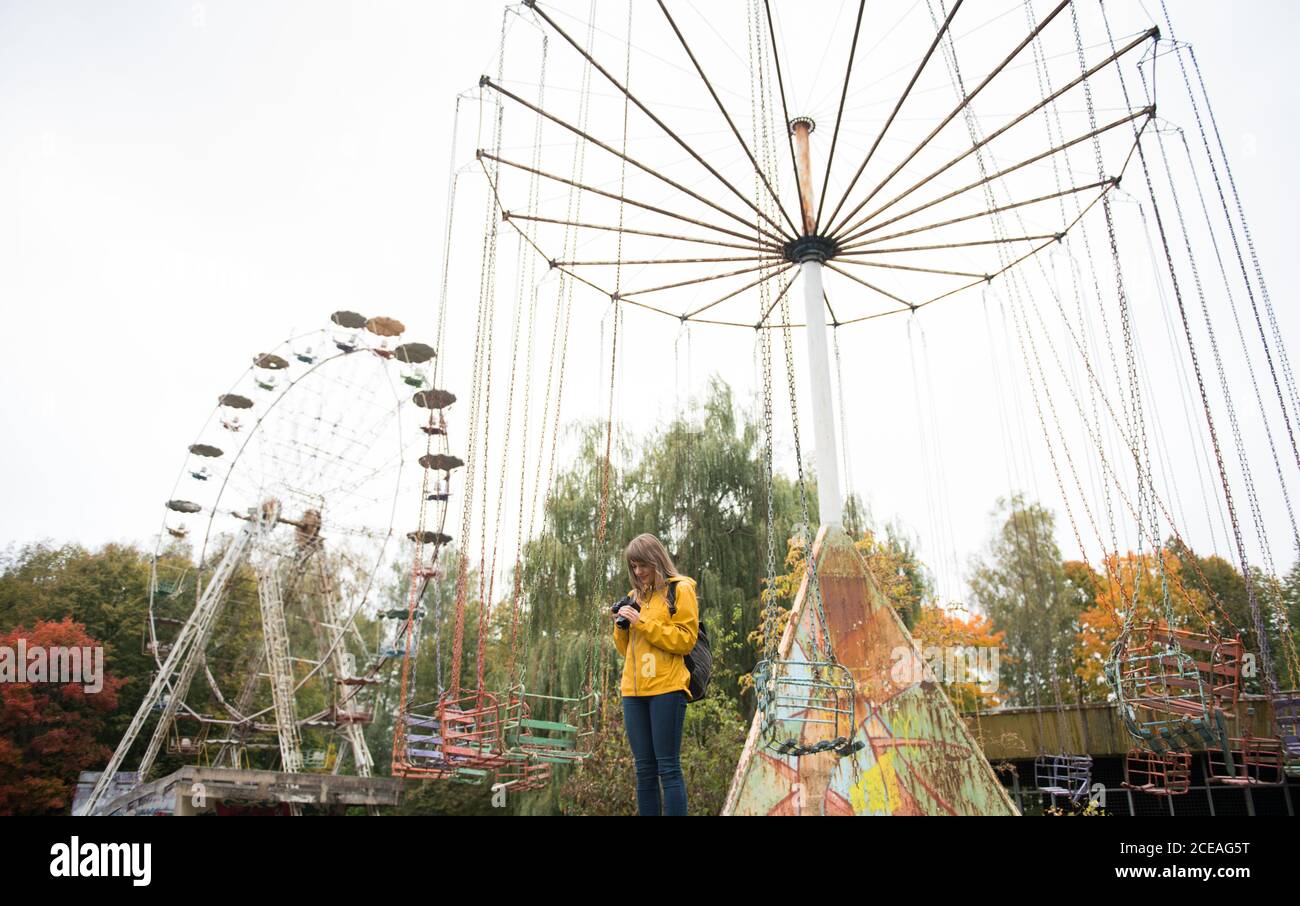 Back view of blond Woman with camera taking photo of desolated ...