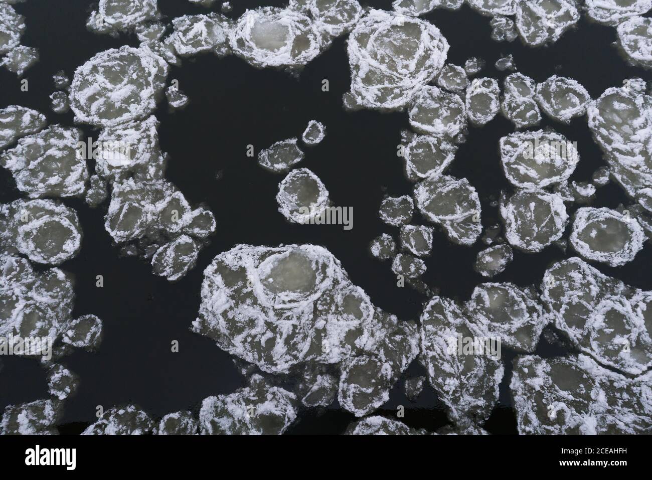 From above shot of ice plates covered with snow floating on surface of ...