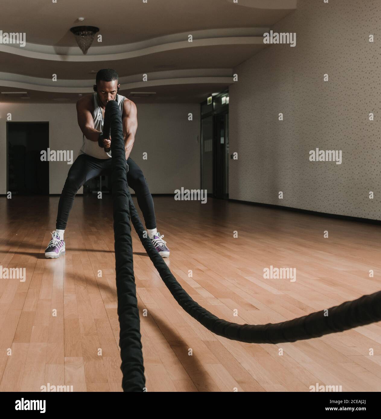 Black guy exercising with ropes in gym Stock Photo - Alamy