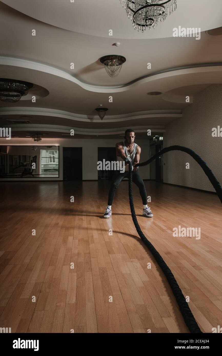 Black guy exercising with ropes in gym Stock Photo - Alamy