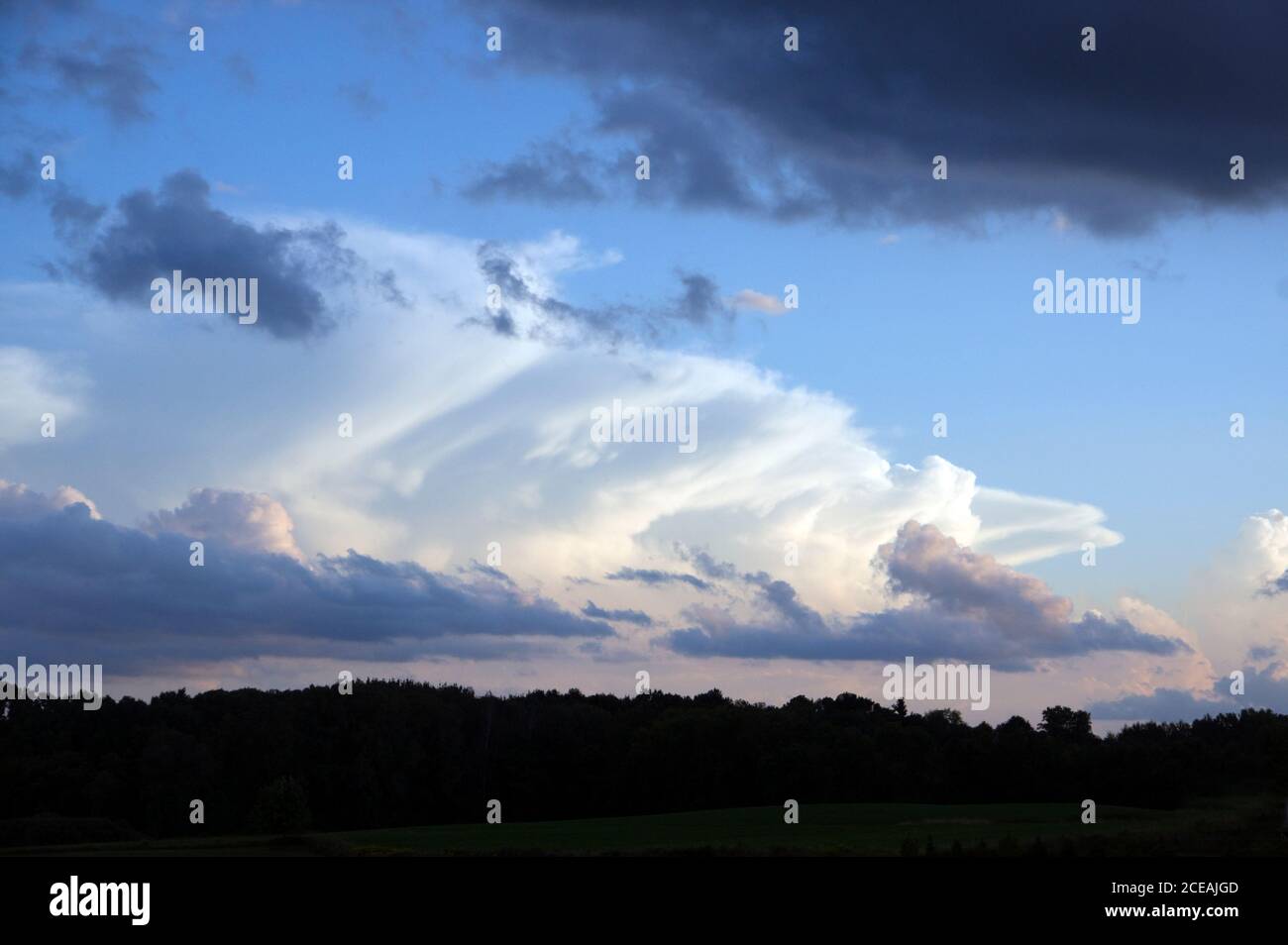 Changing skies, windblown turbulent cumulus clouds beneatrh dark ...