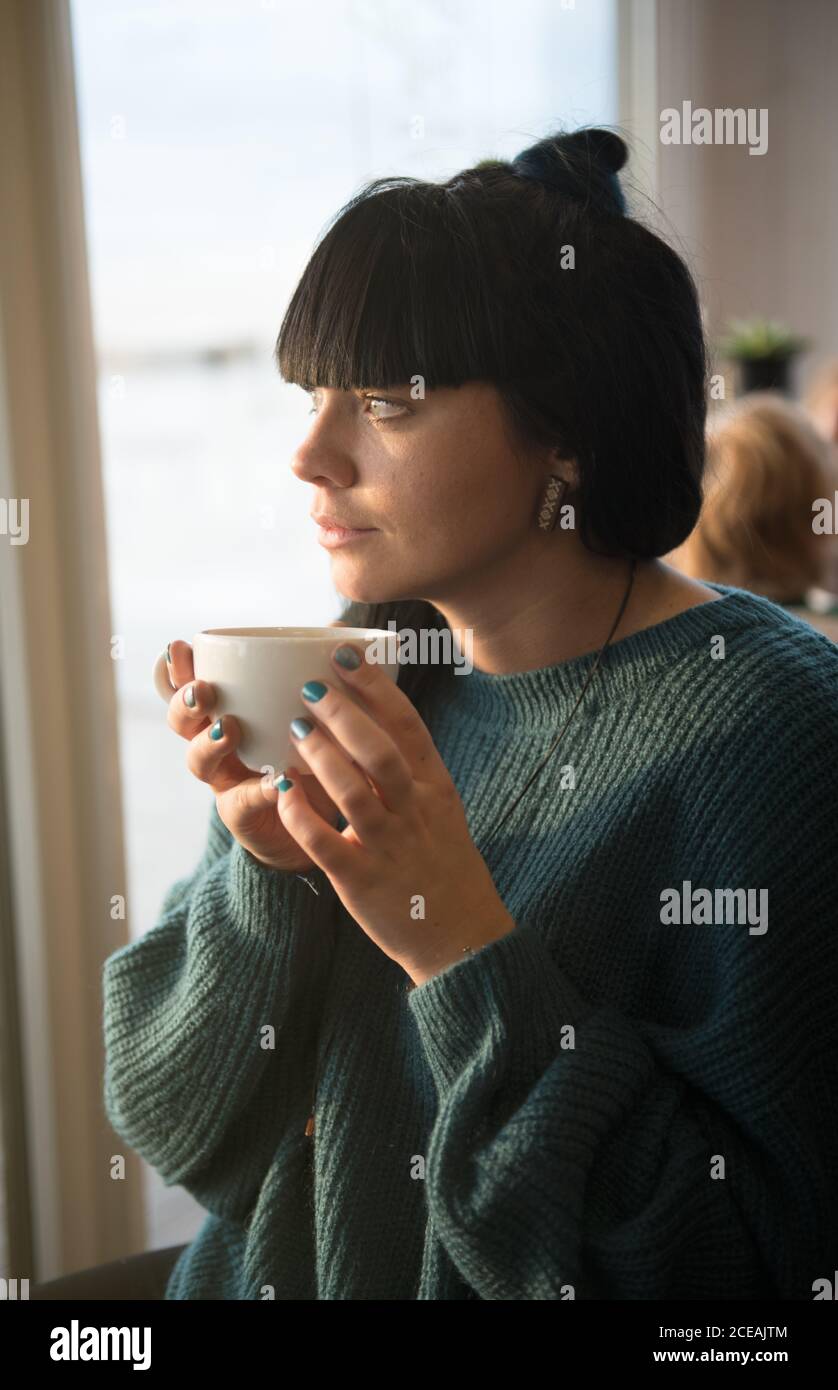 Woman looking out through the window Stock Photo - Alamy