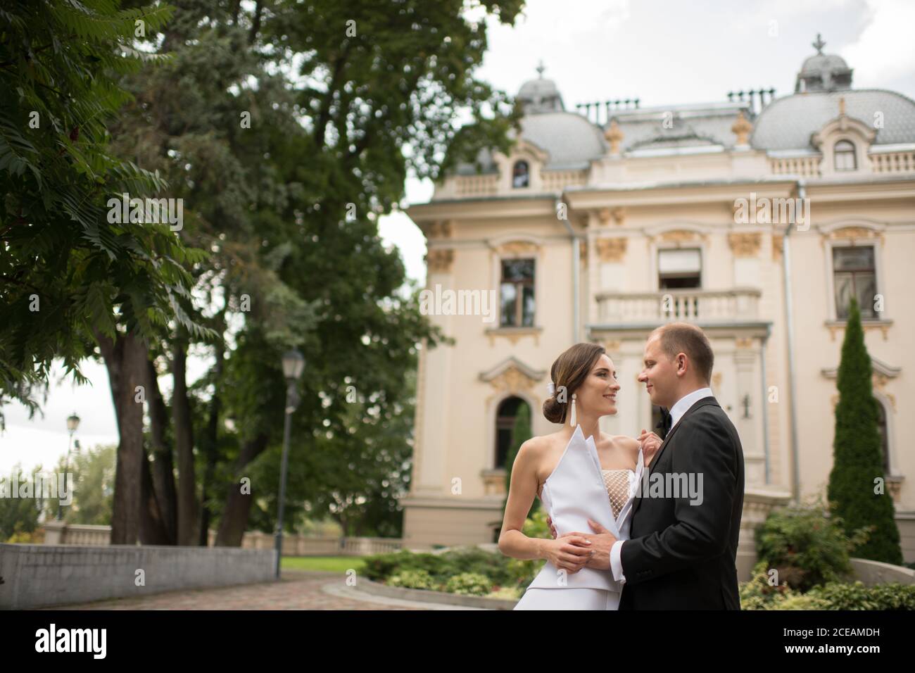 Married couple embracing near luxury building Stock Photo - Alamy