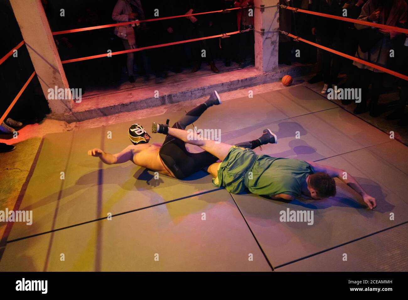 Strong fighters lying on mats of wrestling ring fighting in struggle ...