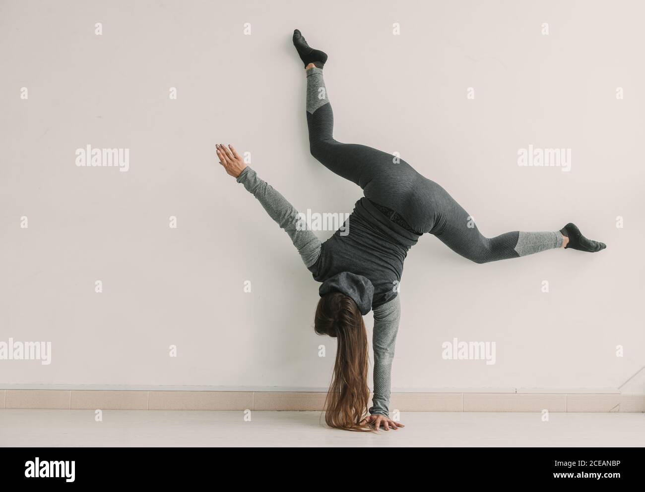 Back view of young sportive Woman doing handstand and leg split in ... Back view of young sportive Woman doing handstand and leg split in ...
