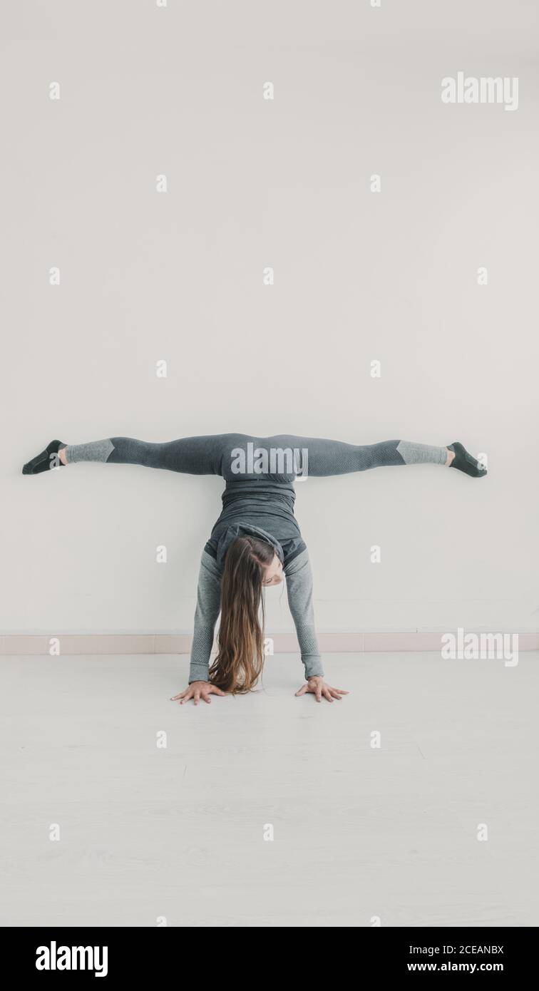 Back view of young sportive Woman doing handstand and leg split in ... Back view of young sportive Woman doing handstand and leg split in ...