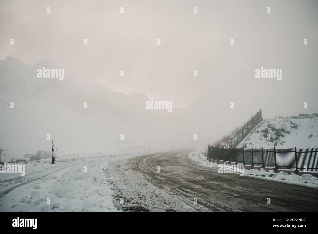 Snowy route running between mountains in fog in Pyrenees Stock Photo ...