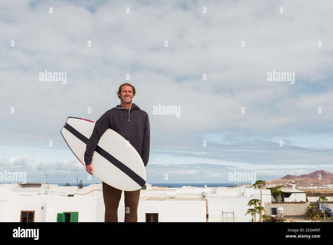 Handsome man standing surfing board hi-res stock photography and images ...