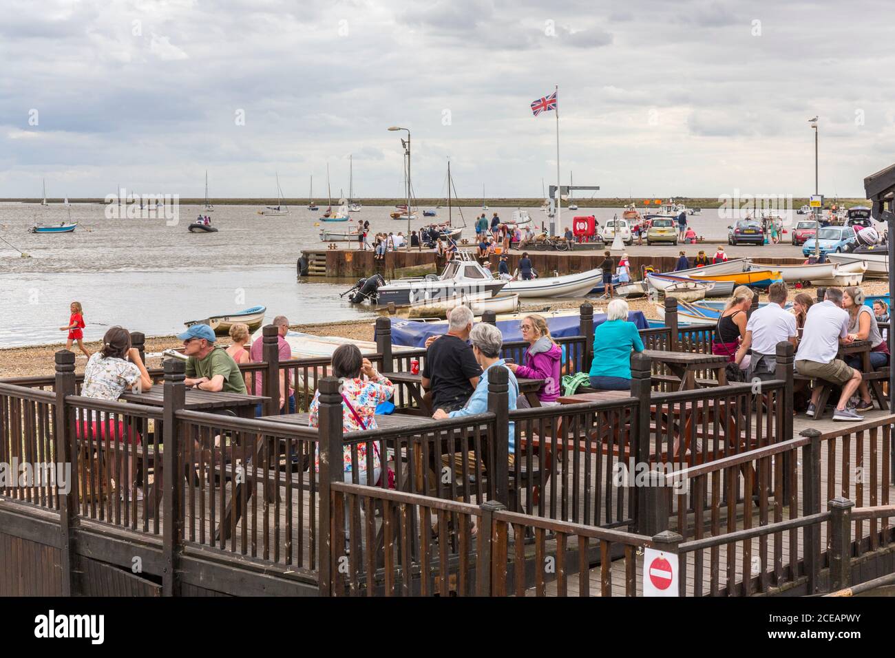 Orford Quay at Orford, Suffolk UK. Customers at The Riverside Tearoom ...