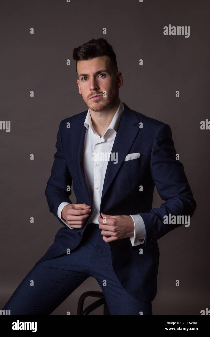Stylish serious man wearing dark blue classy suit with white shirt and ...