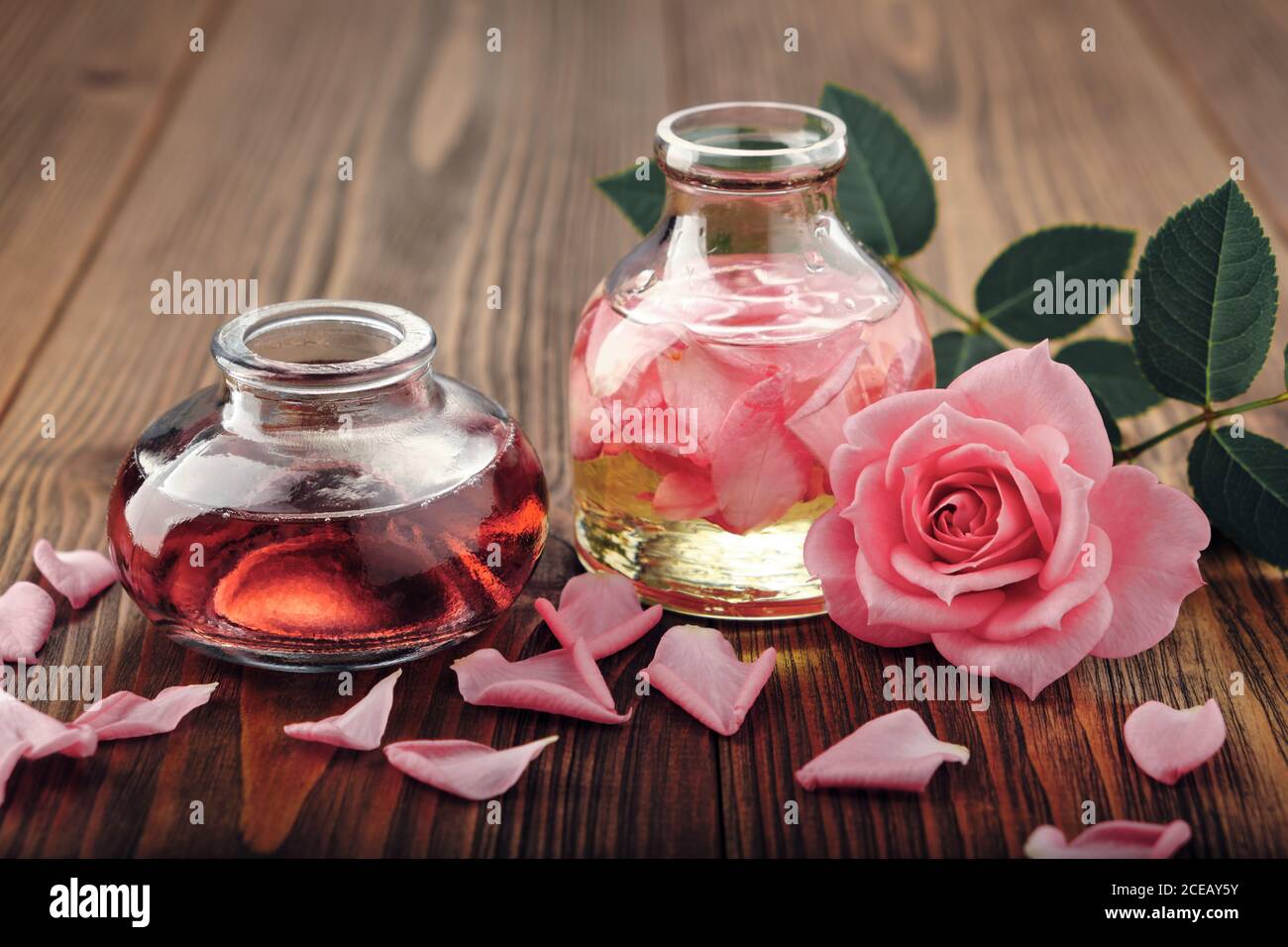Rose flower, flavored water and essential oil bottle Stock Photo - Alamy