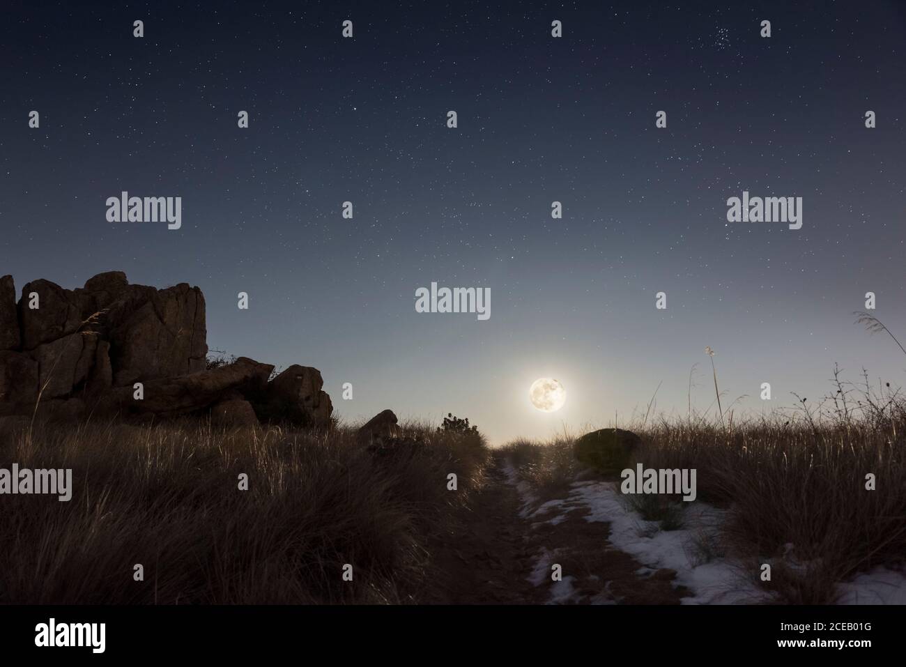 Full moon rising over the hill on a winter night Stock Photo - Alamy