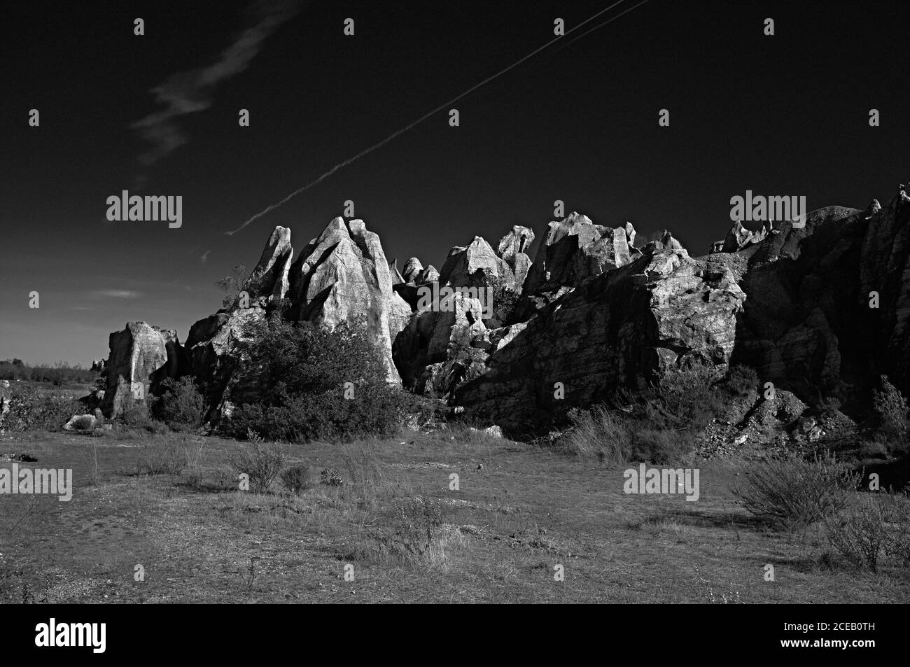 High steep sharp rocks with trees growing at bottom on background of ...