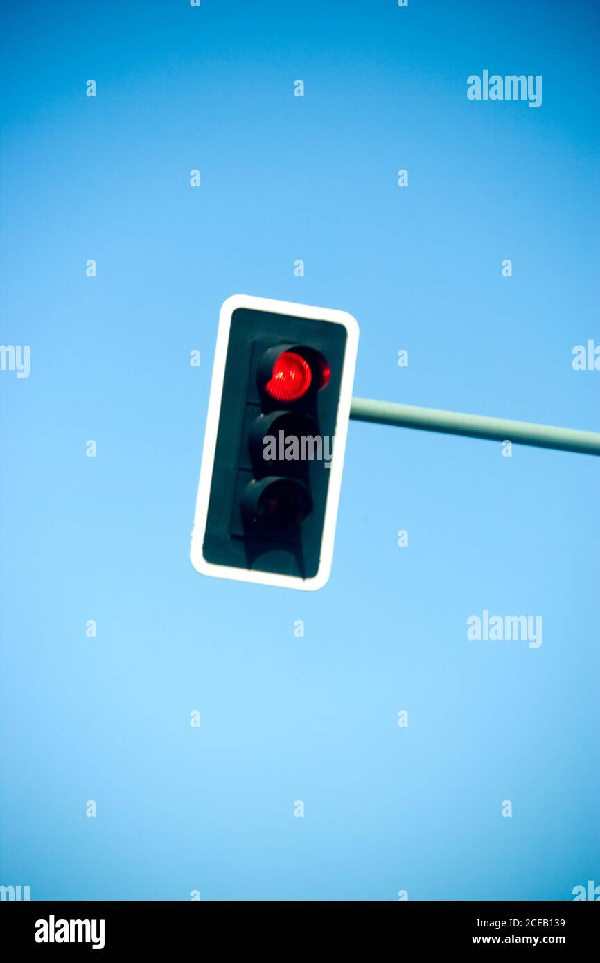 From below of modern city traffic light burning with red prohibiting ...