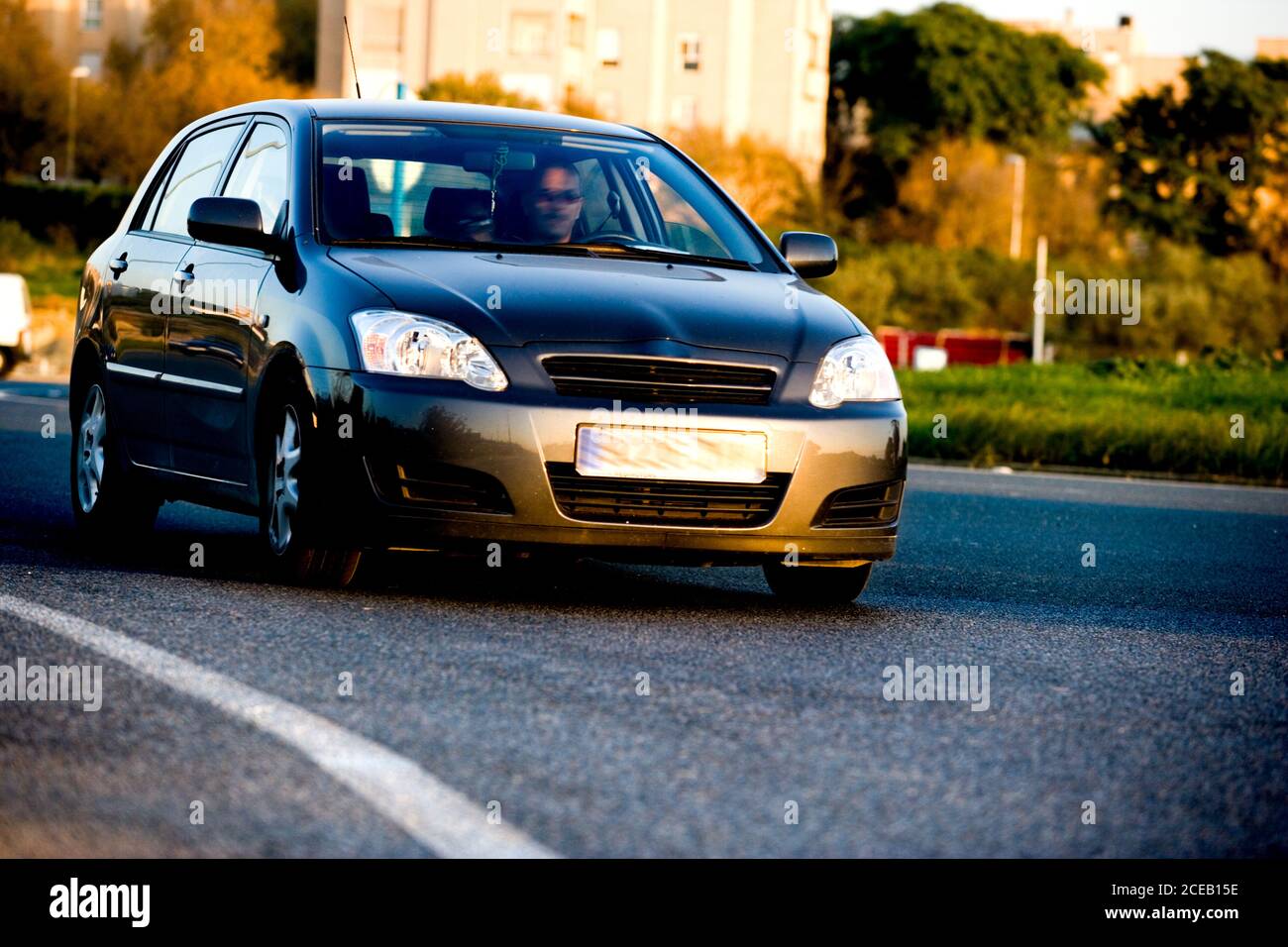 View of modern cars driving on asphalt road in daylight on green nature ...
