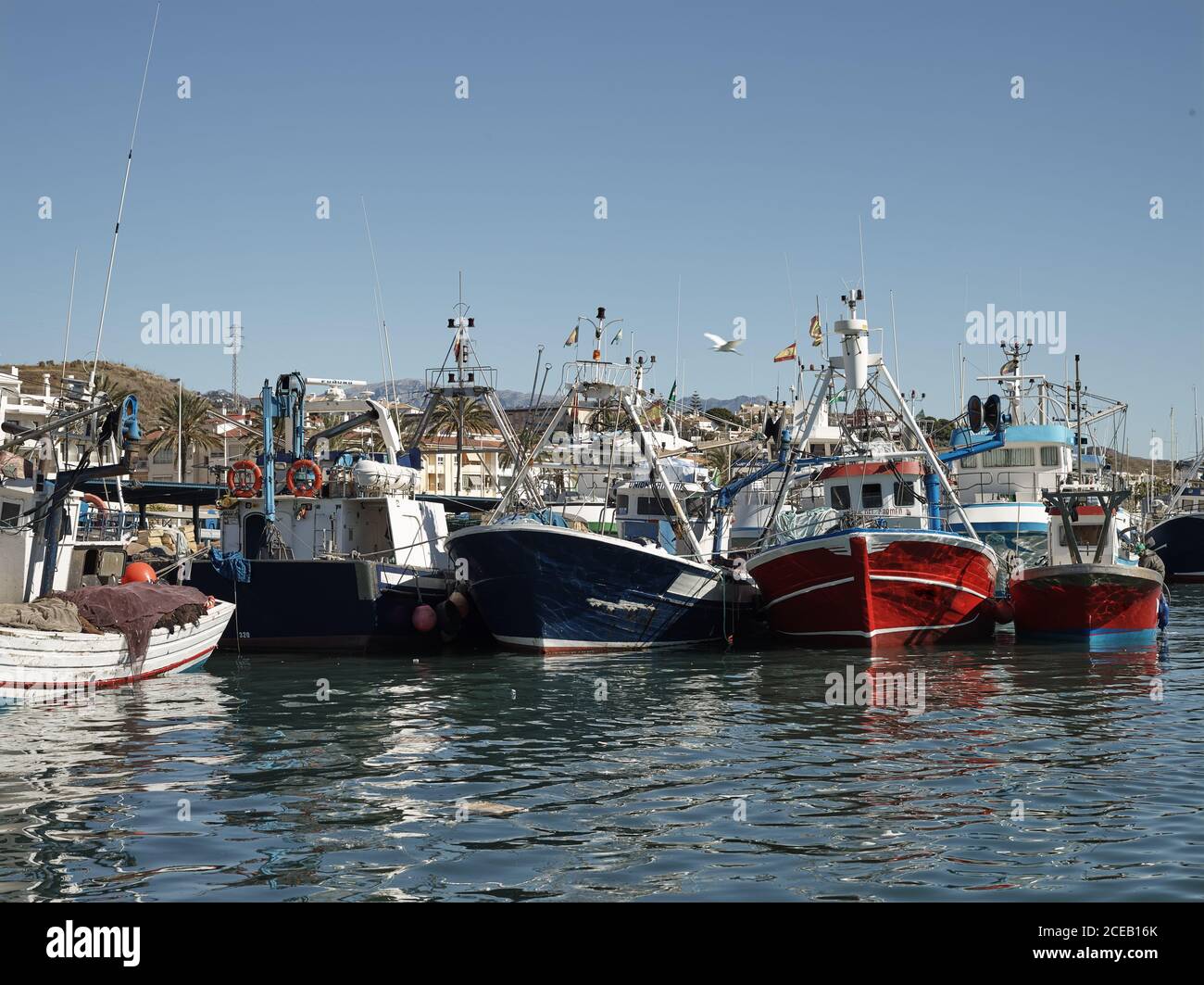 Fishing motorboats floating near shore of blue still river on ...