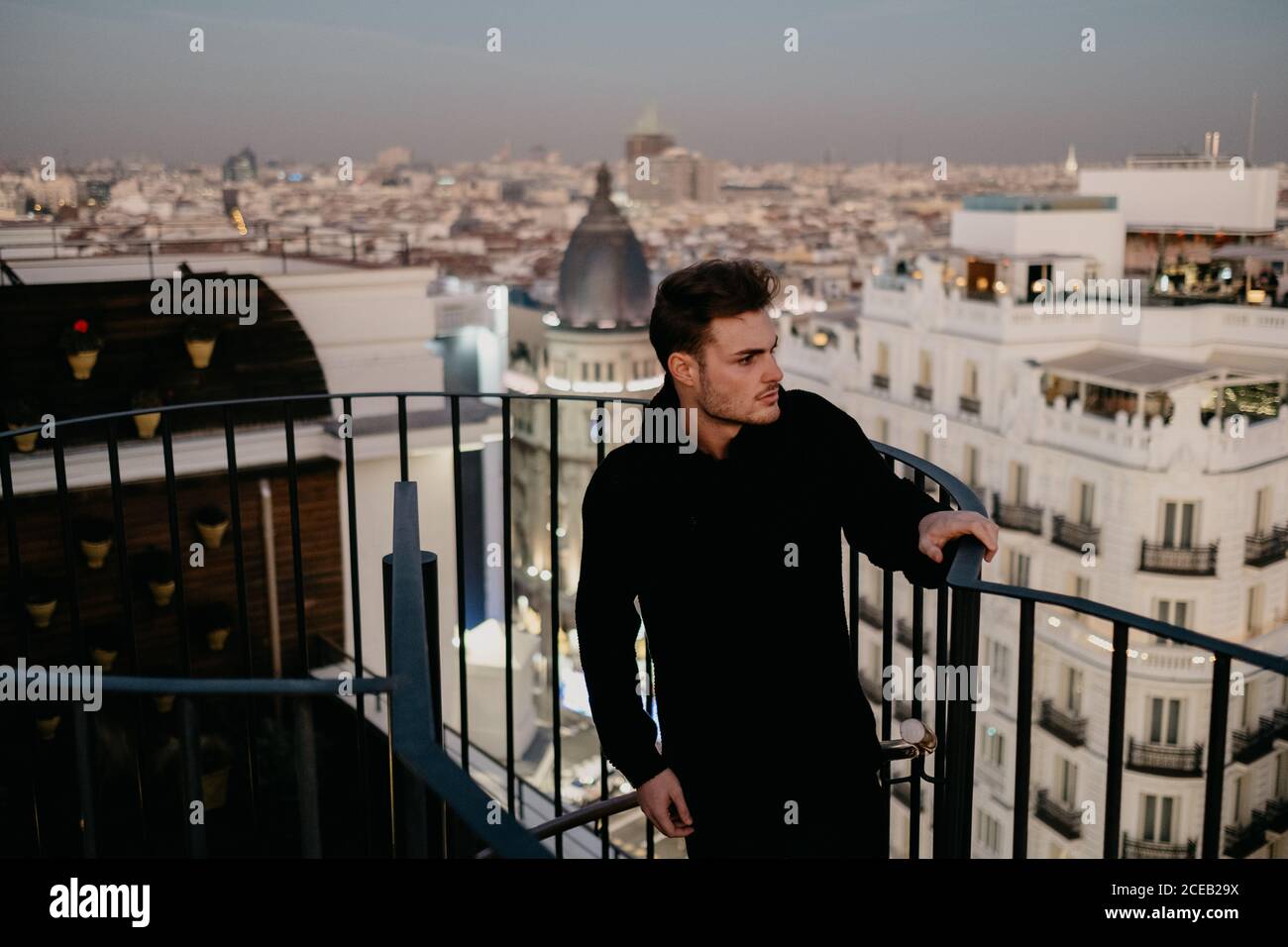Handsome man on roof near old buildings and huge banner Stock Photo - Alamy