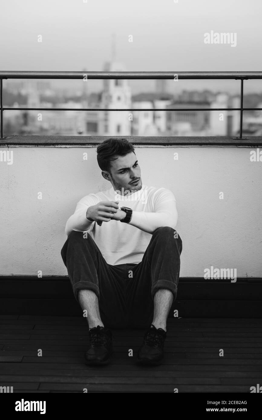 Handsome man on roof near old buildings and huge banner Stock Photo - Alamy