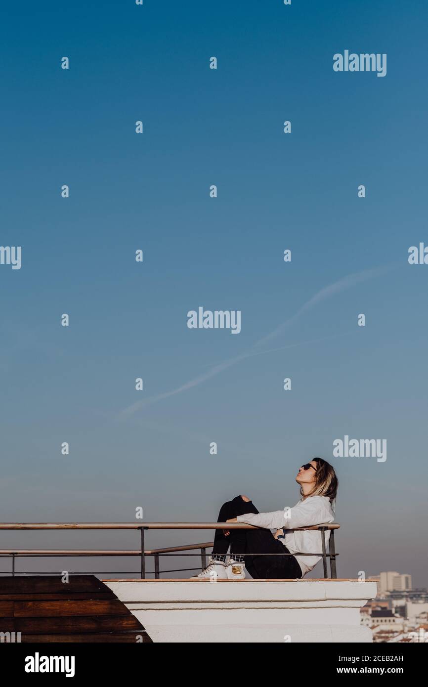 Stylish woman sitting on roof hi-res stock photography and images - Alamy
