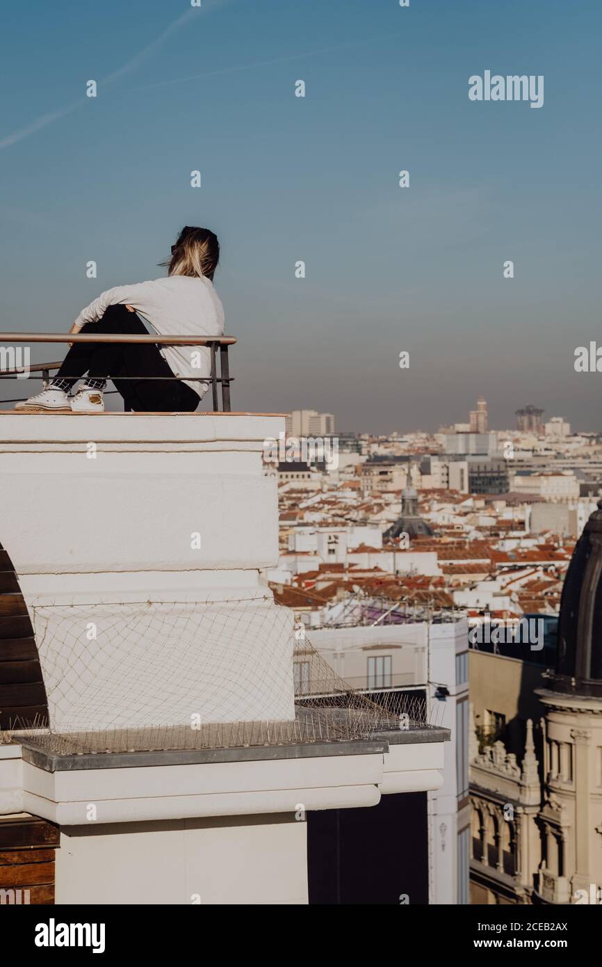 Attractive Woman sitting on roof Stock Photo - Alamy