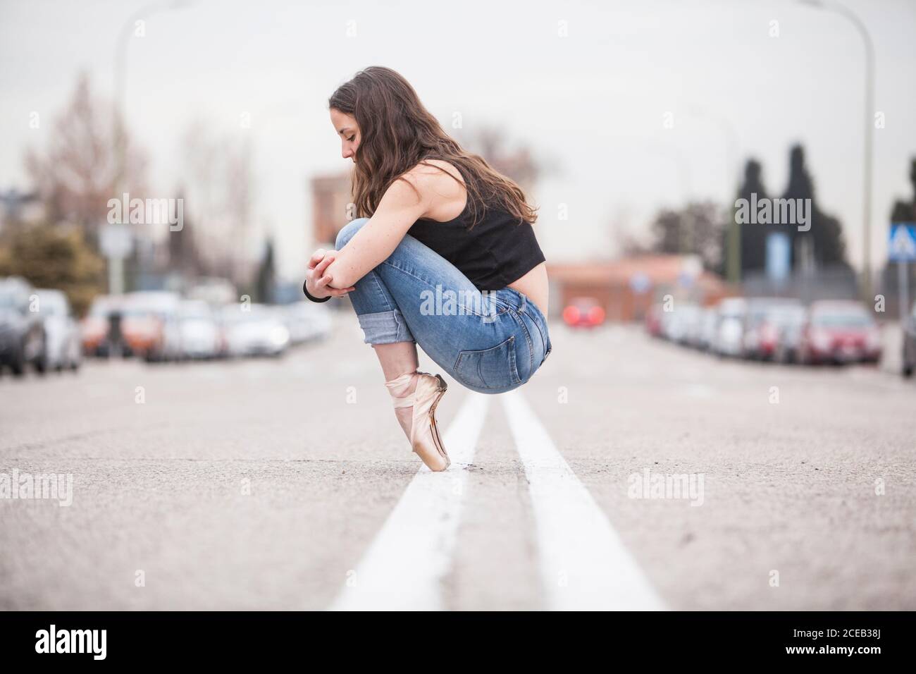 Woman dancer on ballet tips and jeans on the street and hugging his ...