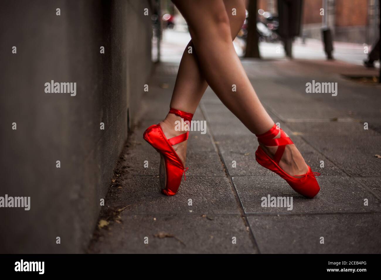 Red head ballerina with black tutu and red ballet tips warming up to ...